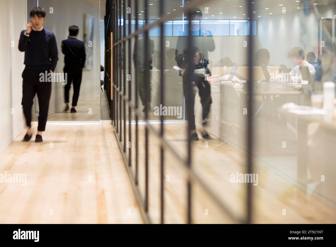 Man walking through the office while talking on the phone Stock Photo ...