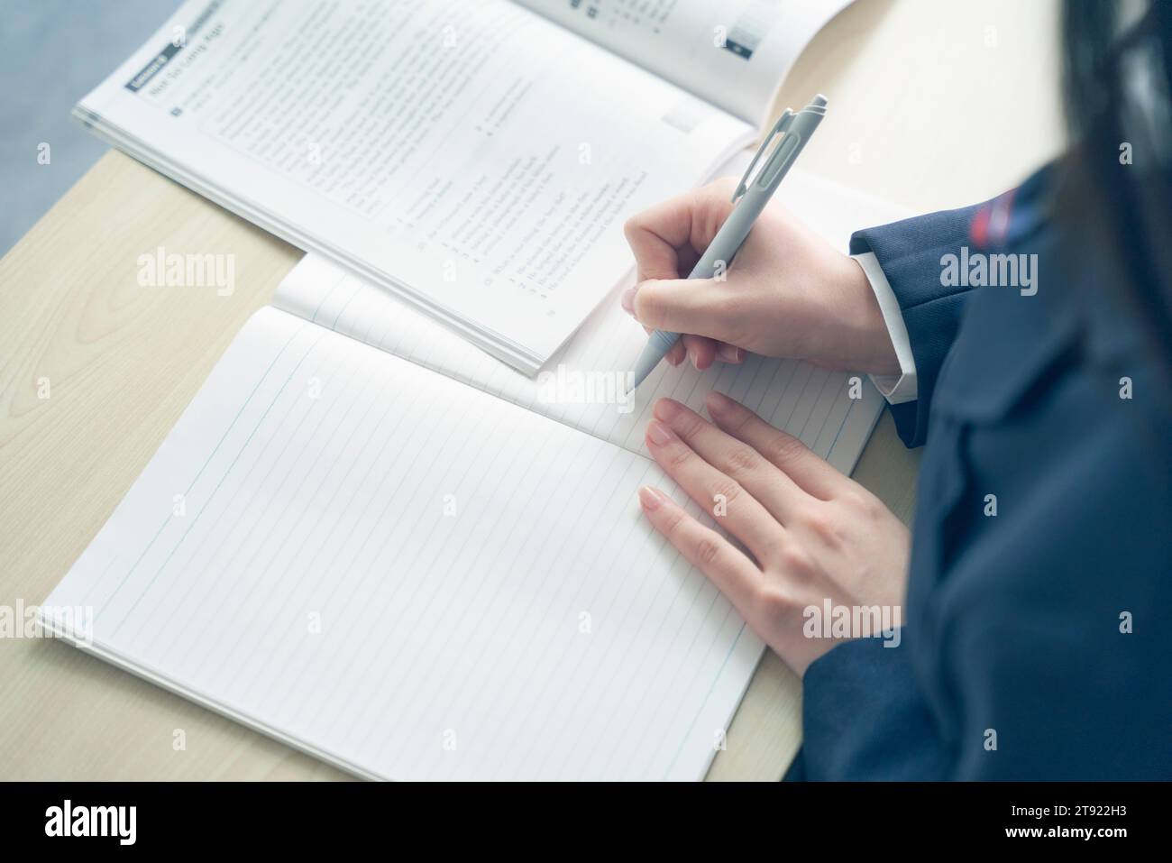 Female student writing in a notebook Stock Photo - Alamy