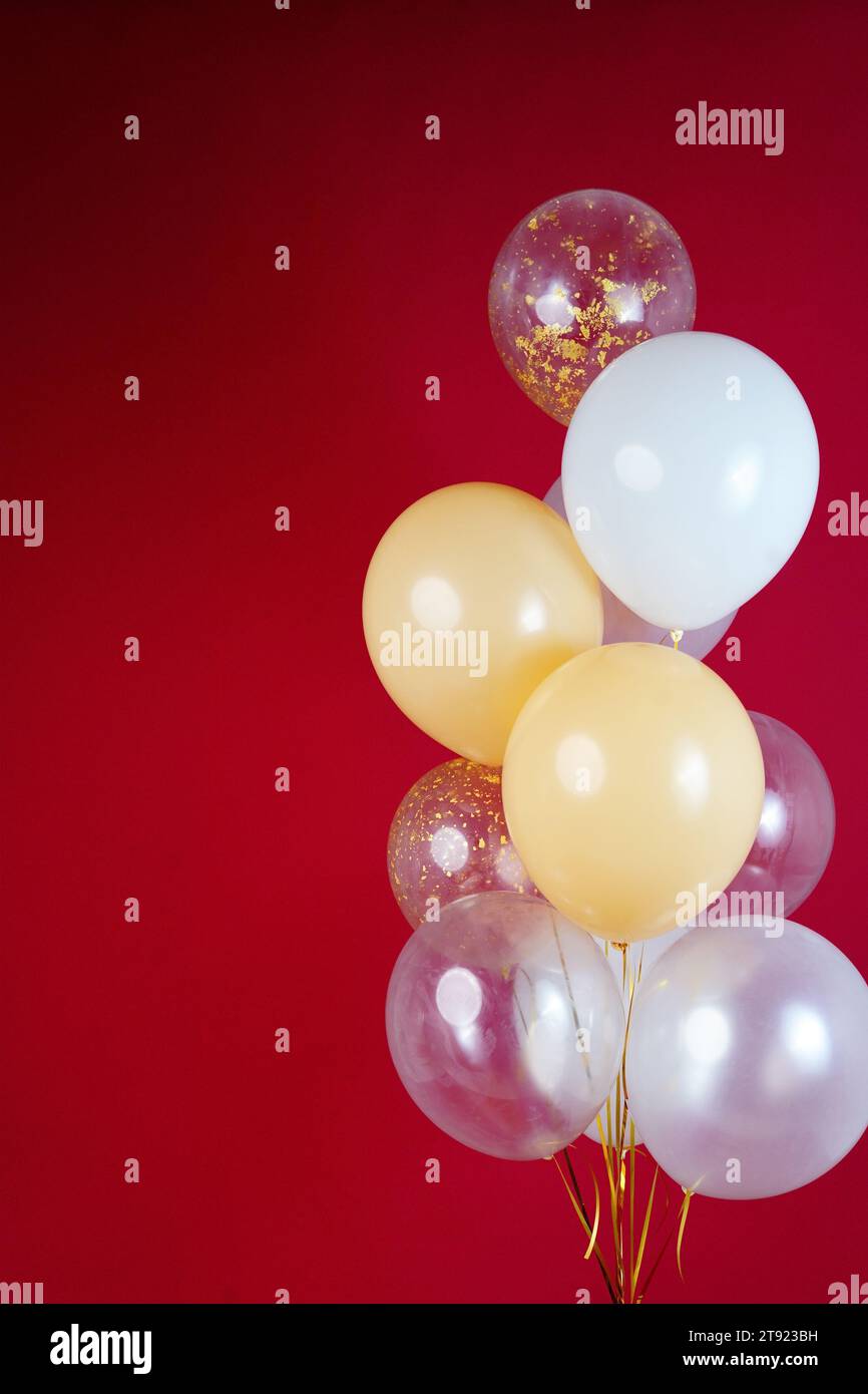 A bunch of light balloons on a red background. Vertical Photo Space for ...
