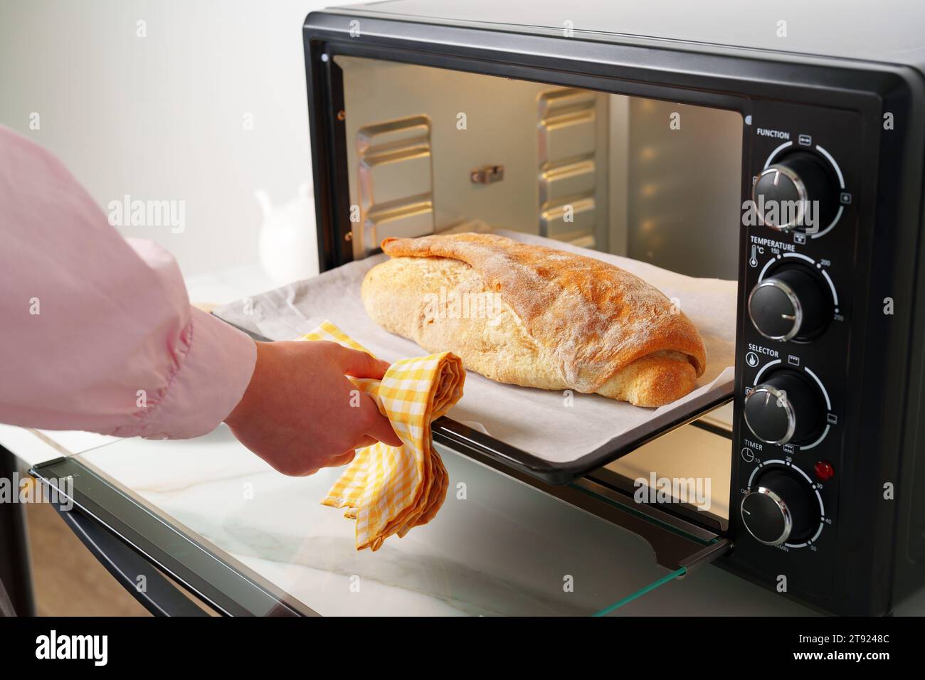 Woman's hands taking fresh bakery out of mini oven Stock Photo - Alamy