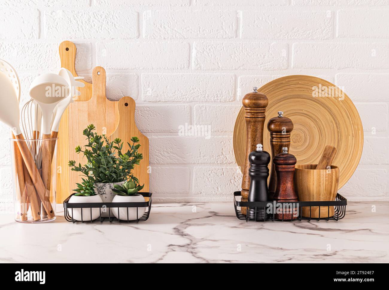 Set of kitchen utensils, various spice grinders on marble countertop in ...