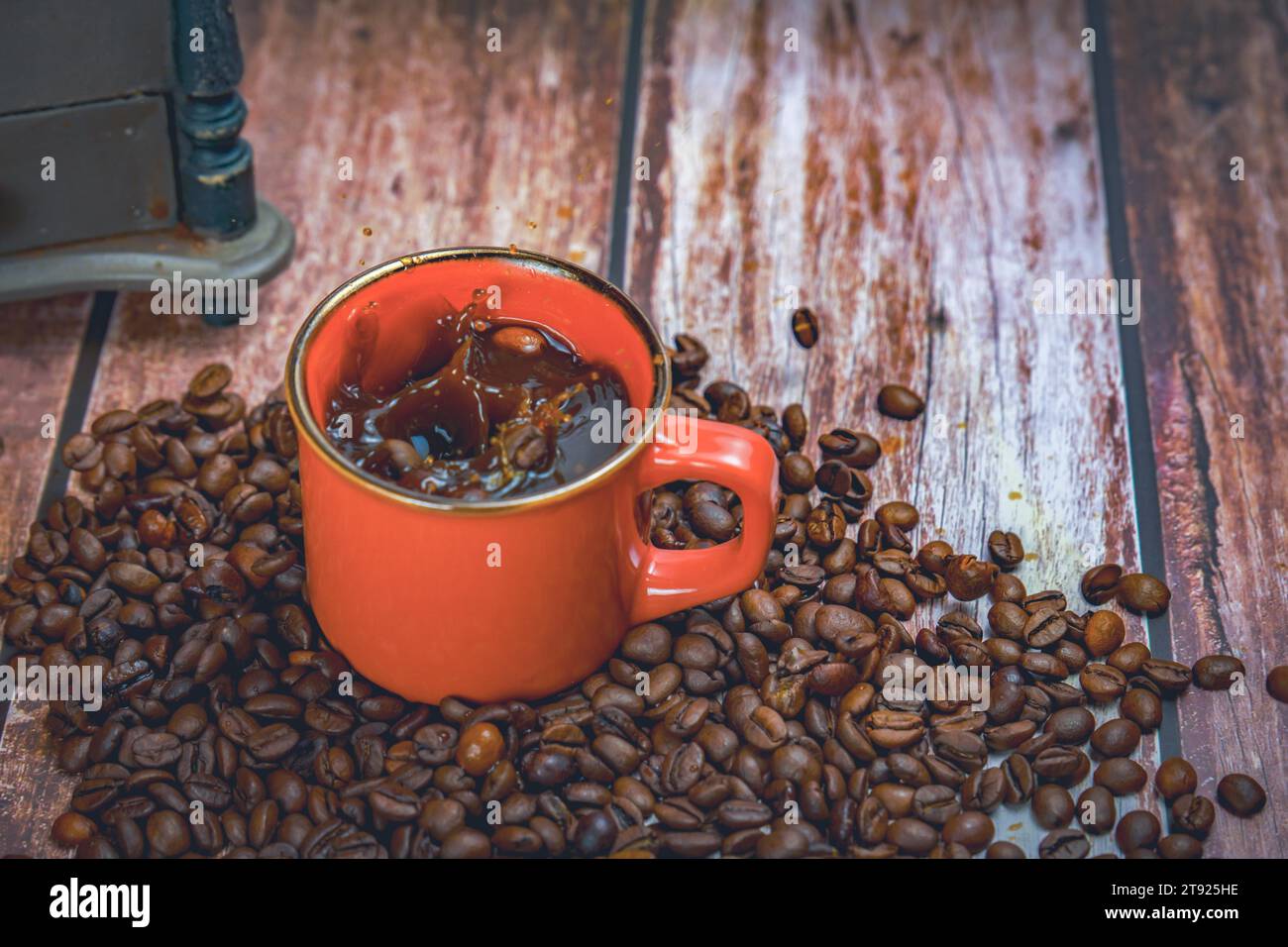 Red coffee mug with coffee beans falling inside with splash effect ...