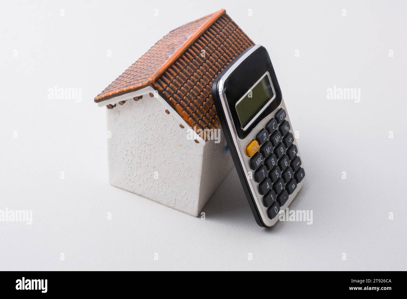Model house and calculator placed on white background Stock Photo - Alamy