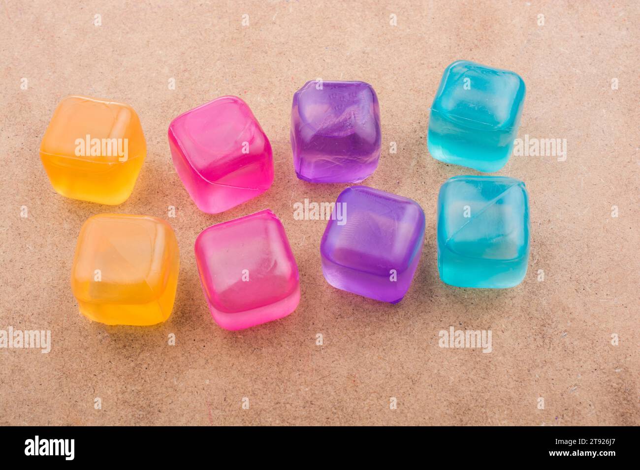 Fake colorful ice cubes on a brown background Stock Photo - Alamy