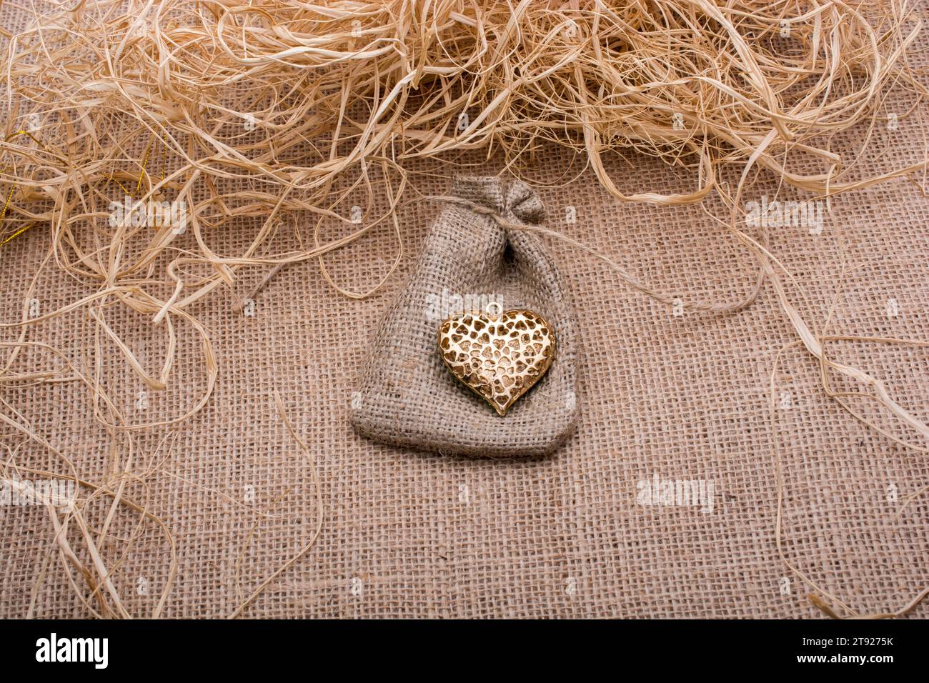 Heart shaped gold color metal object out of sack Stock Photo - Alamy