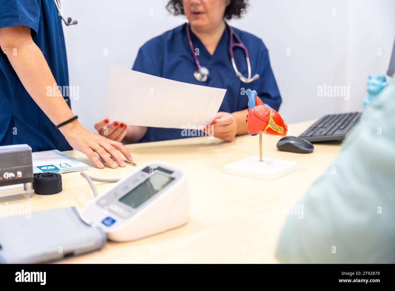 Nurse and doctor sharing paperwork in a cardiology office with a ...