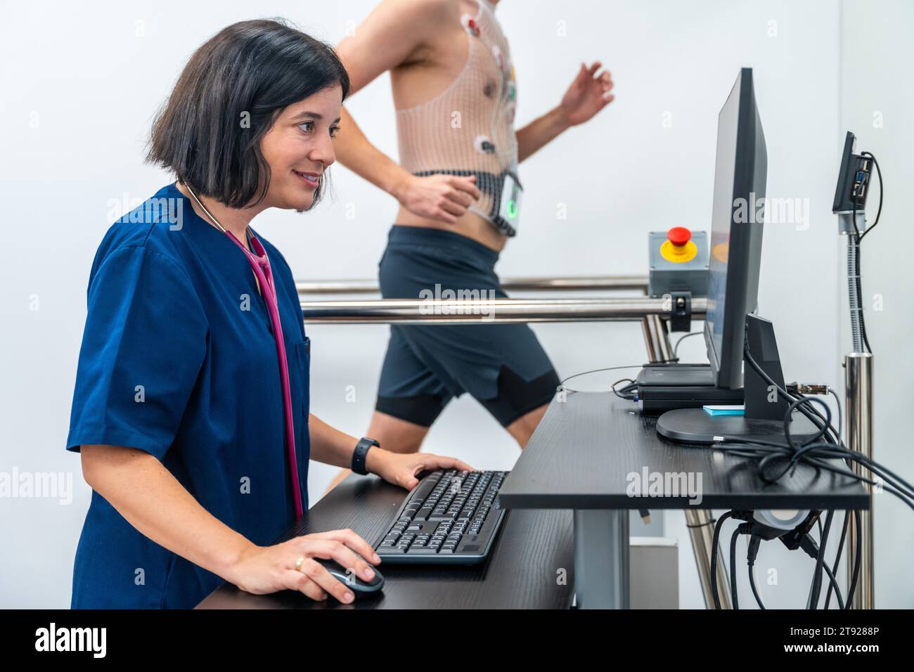 Patient walking along a treadmill performing a cardiovascular stress ...