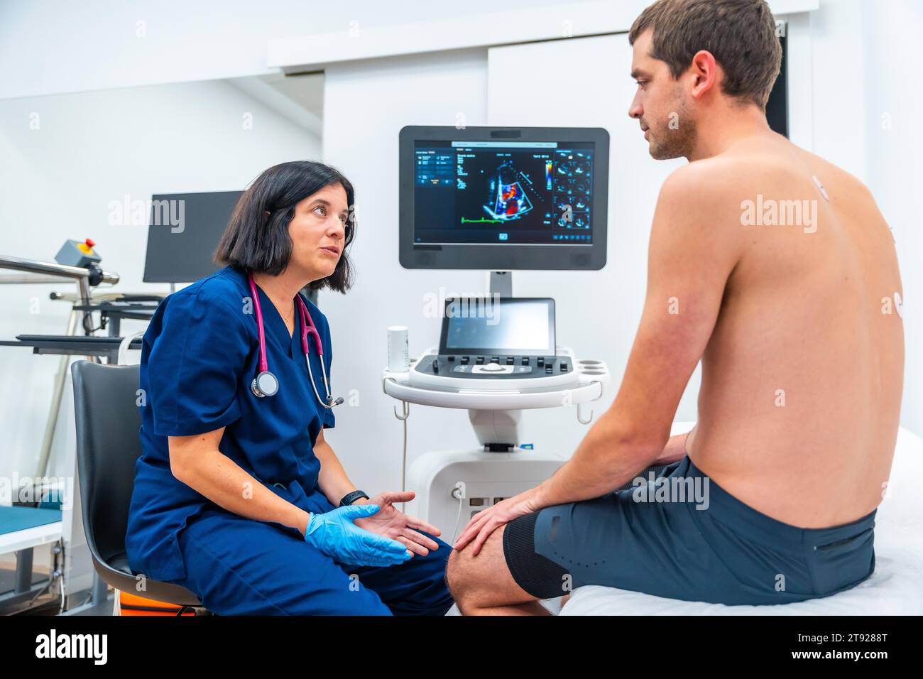 Rear view of a male patient and female doctor cardiologist looking at ...