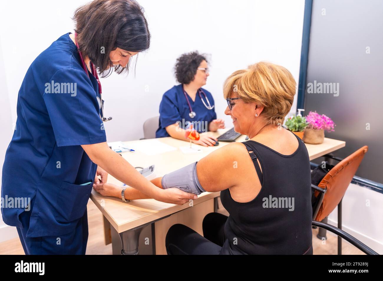 Nurse measuring the blood pressure to a woman patient Stock Photo - Alamy