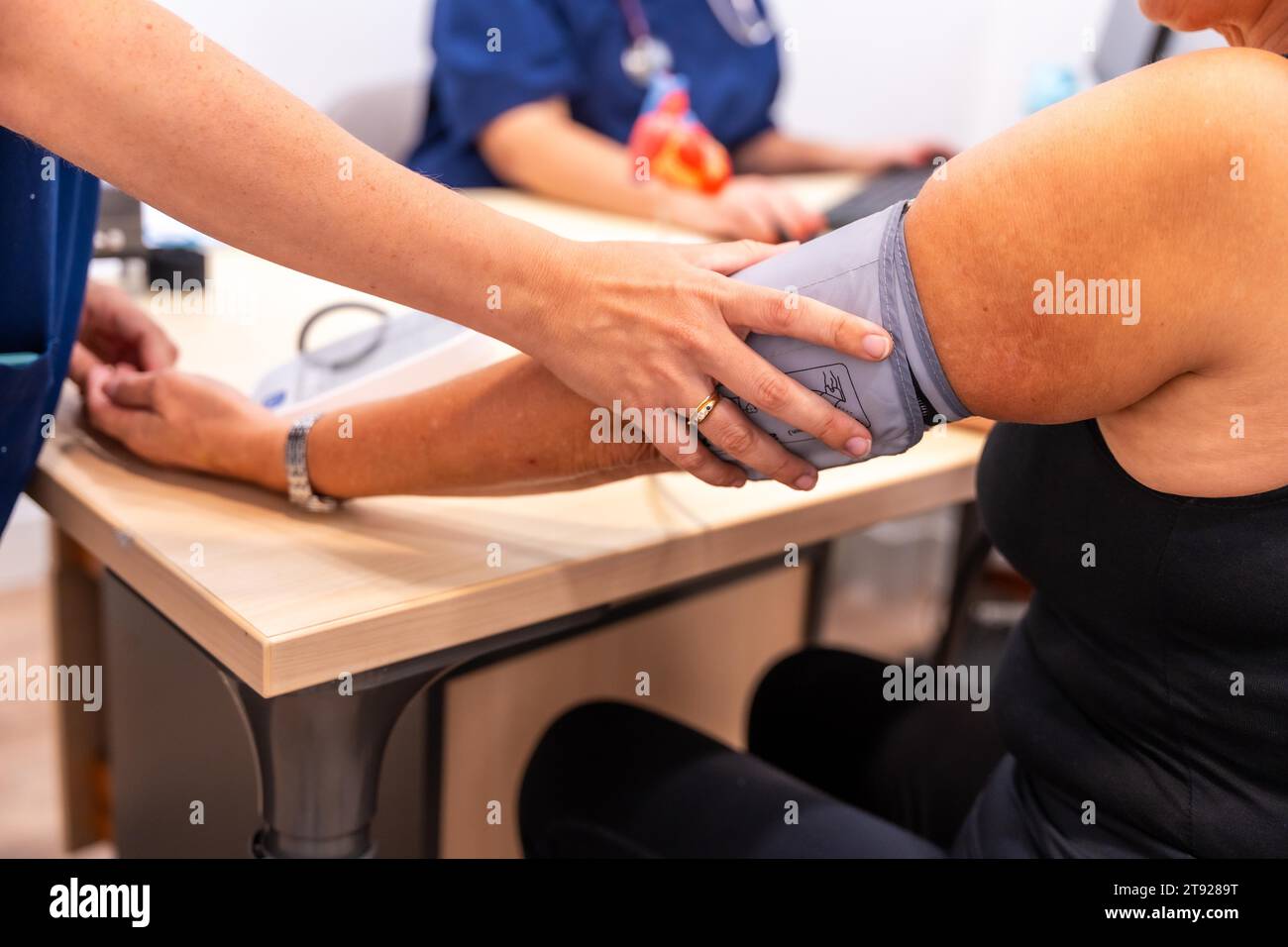 Nurse measuring the blood pressure of a mature patient during a ...