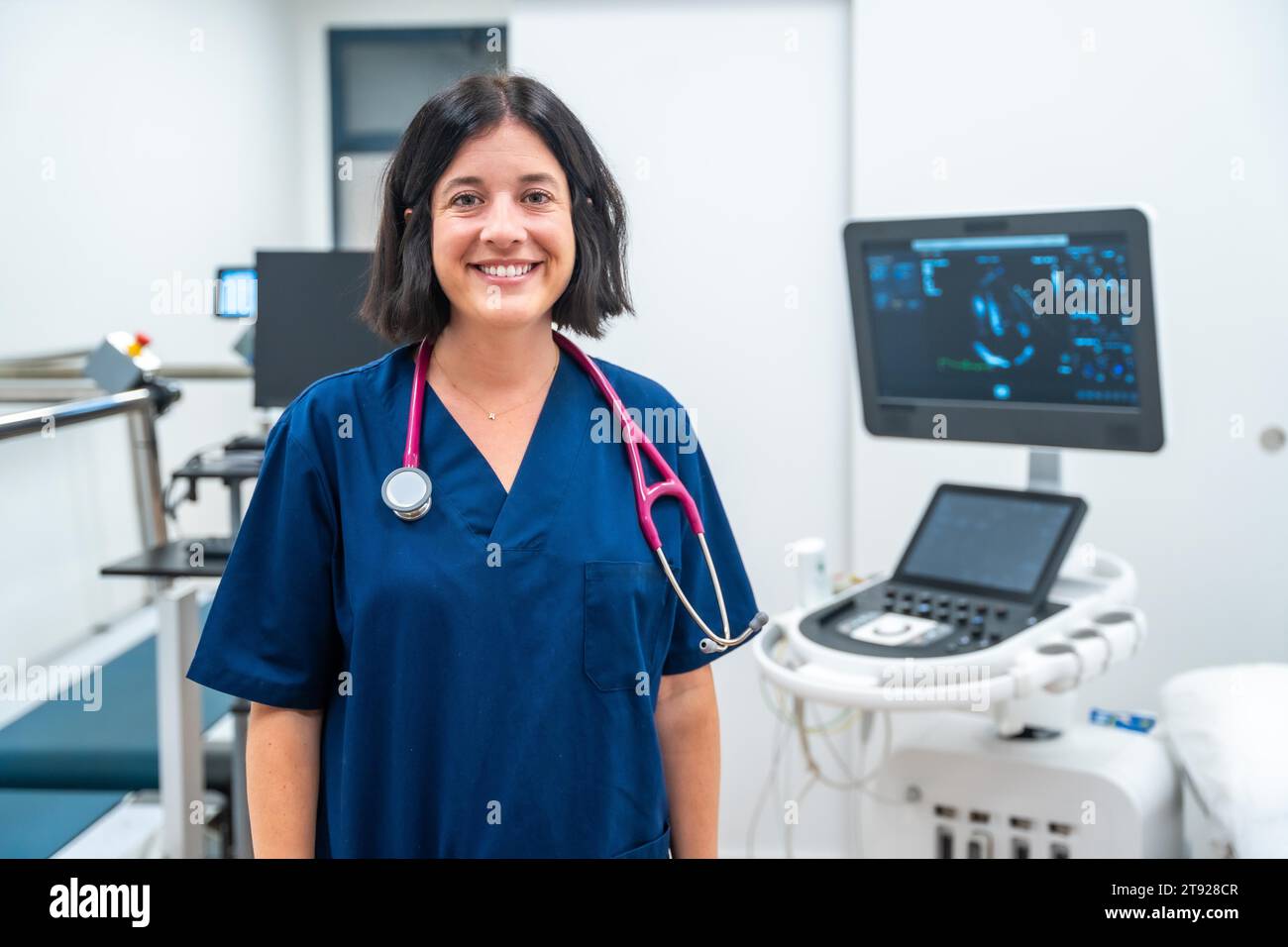 Happy cardiologist standing with arms crossed on a hospital next to ...