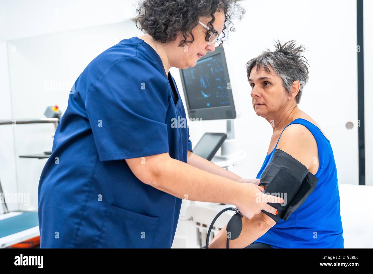 Cardiologist using a stethoscope to listen to the heartbeats of an aged ...