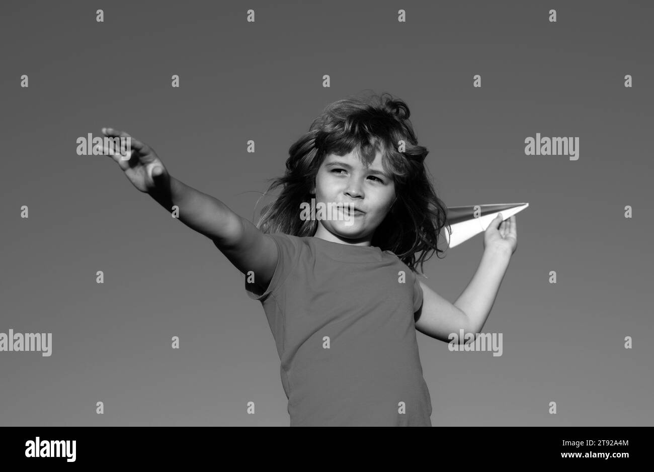 Kid boy throwing a paper plane with blue sky background Stock Photo - Alamy