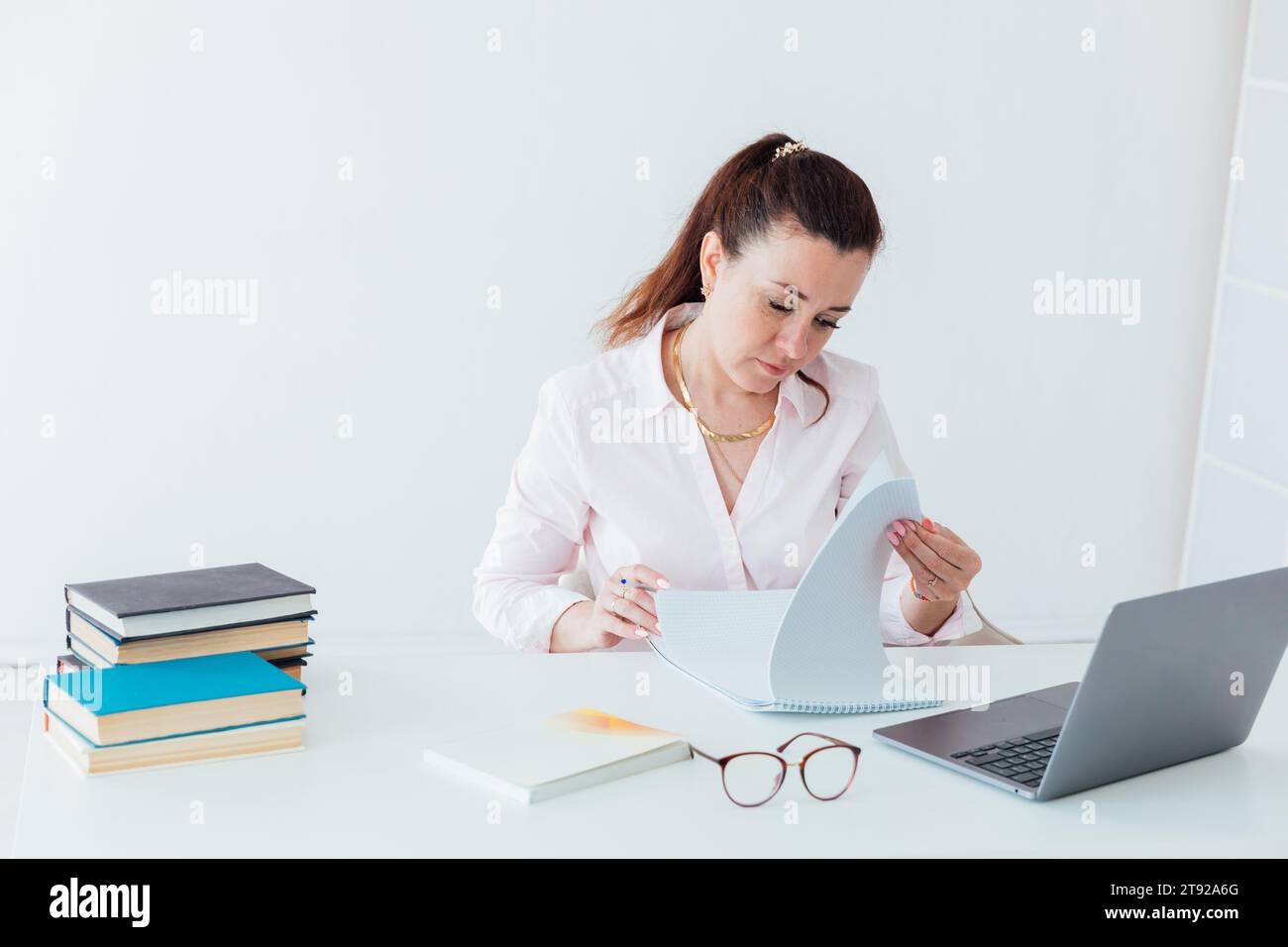 Business woman recording information from laptop Stock Photo - Alamy