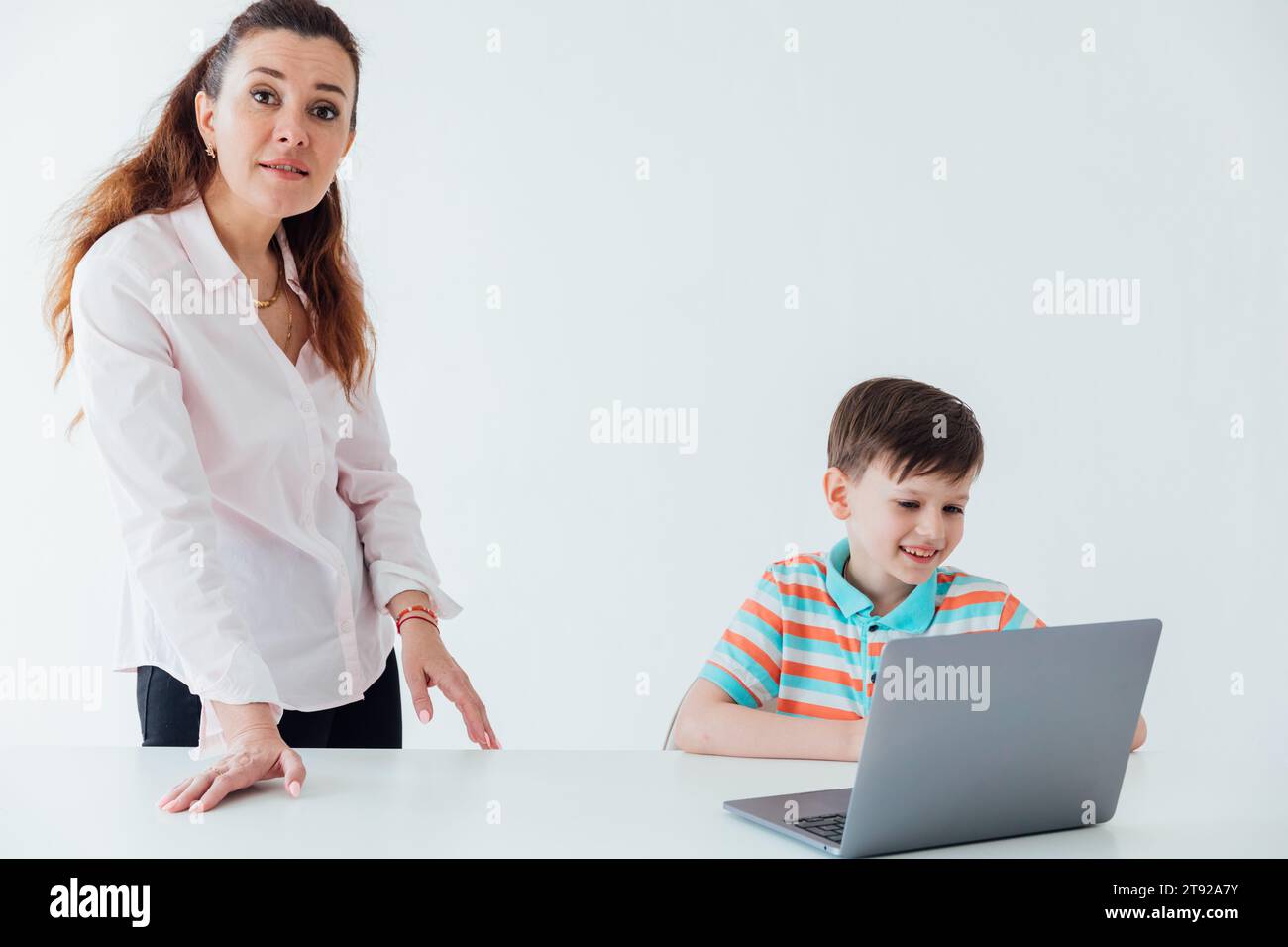 Female teacher teaching boy to use computer Stock Photo - Alamy
