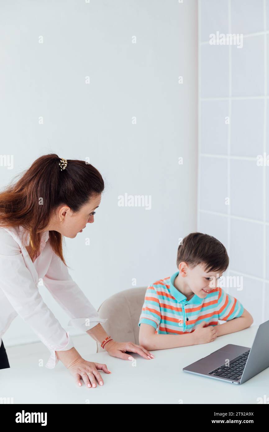 Female teacher teaching boy to use computer Stock Photo - Alamy