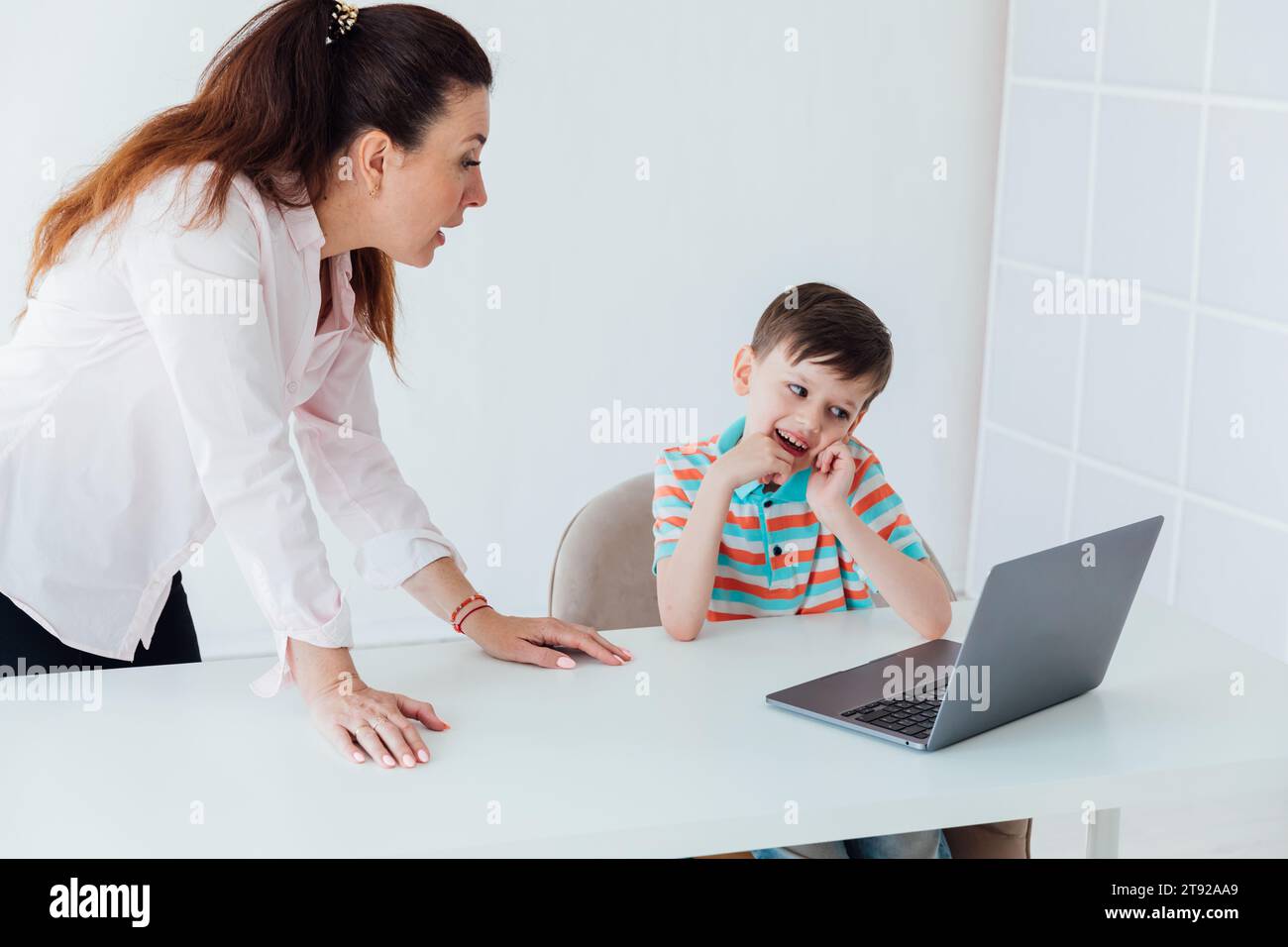 Female teacher teaching boy to use computer Stock Photo - Alamy
