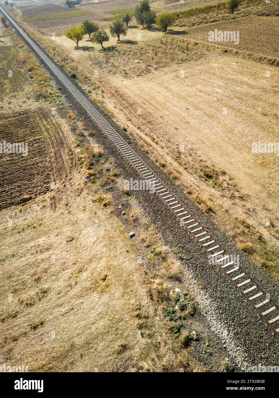 Top view of the train track passing through the arid land, taken with a ...