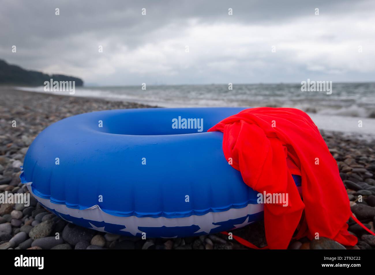 Blue rubber lifebuoy on the shore of a pebble beach Stock Photo - Alamy