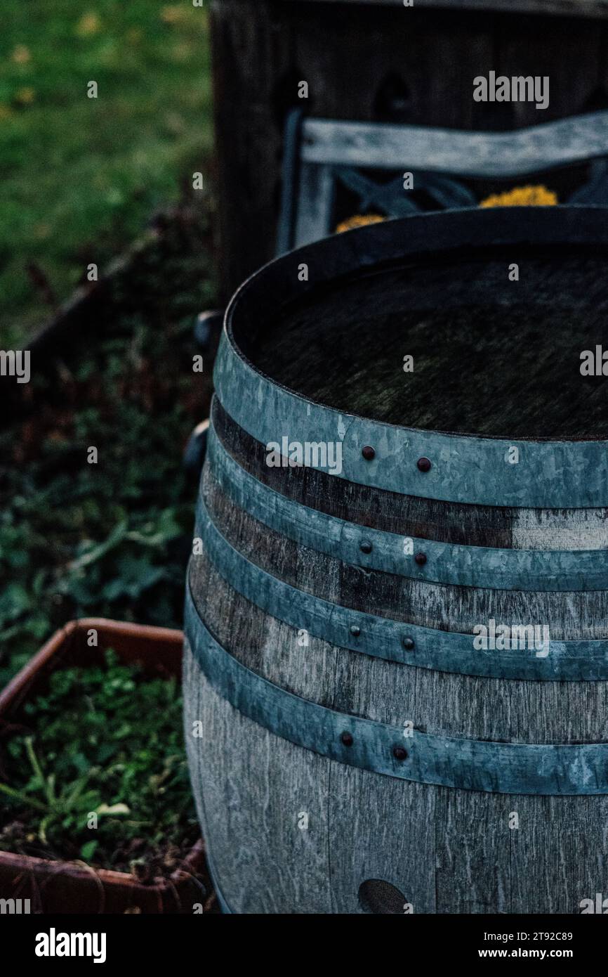 A rustic wooden barrel on a lush green grassy field in a rural setting ...