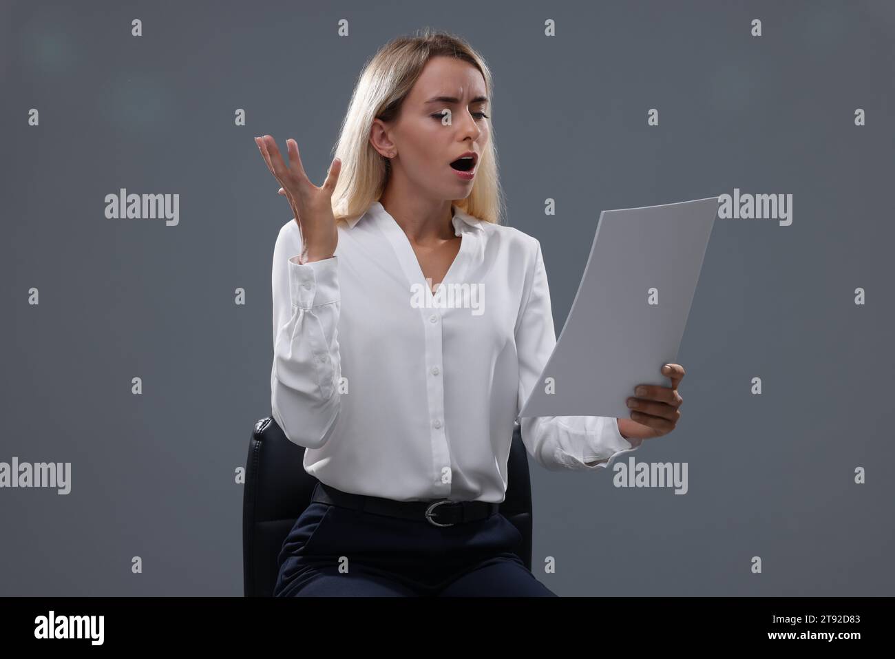 Casting call. Emotional woman with script performing against grey ...
