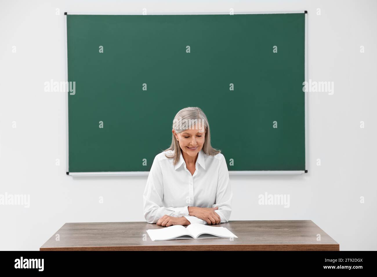 Portrait happy professor sitting desk hi-res stock photography and ...