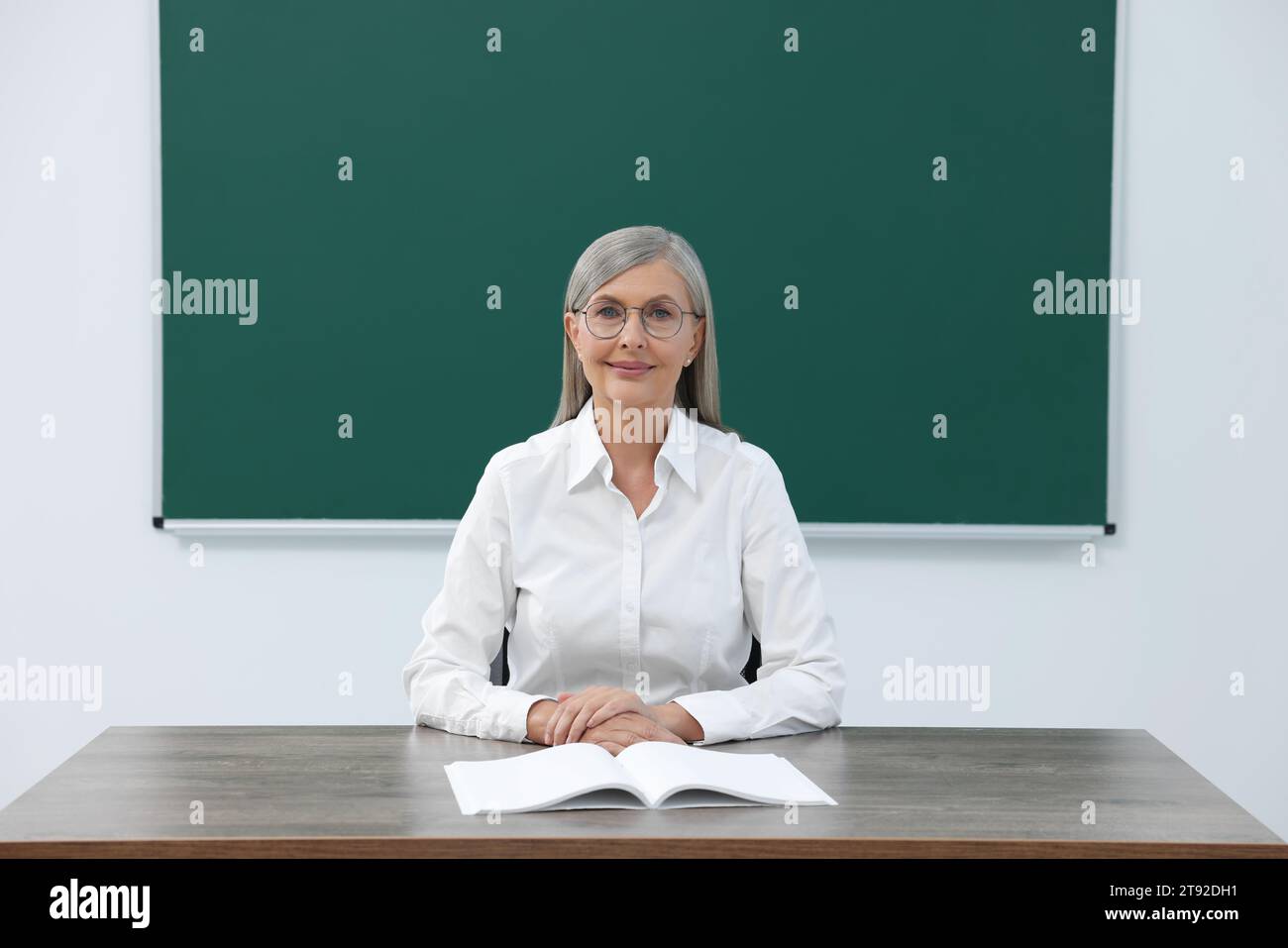 Portrait happy professor sitting desk hi-res stock photography and ...