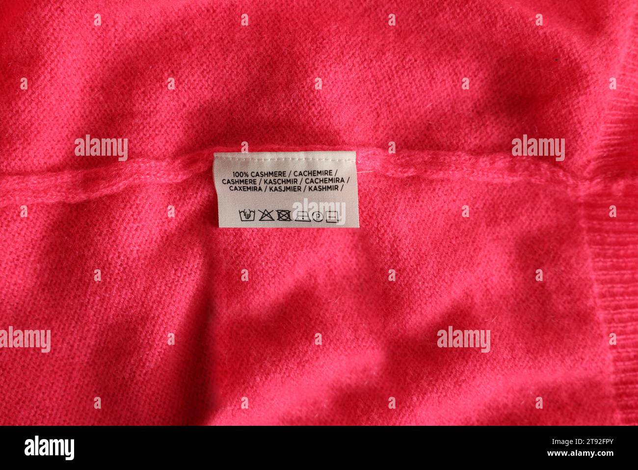 Clothing label in different languages on pink garment, top view Stock ...