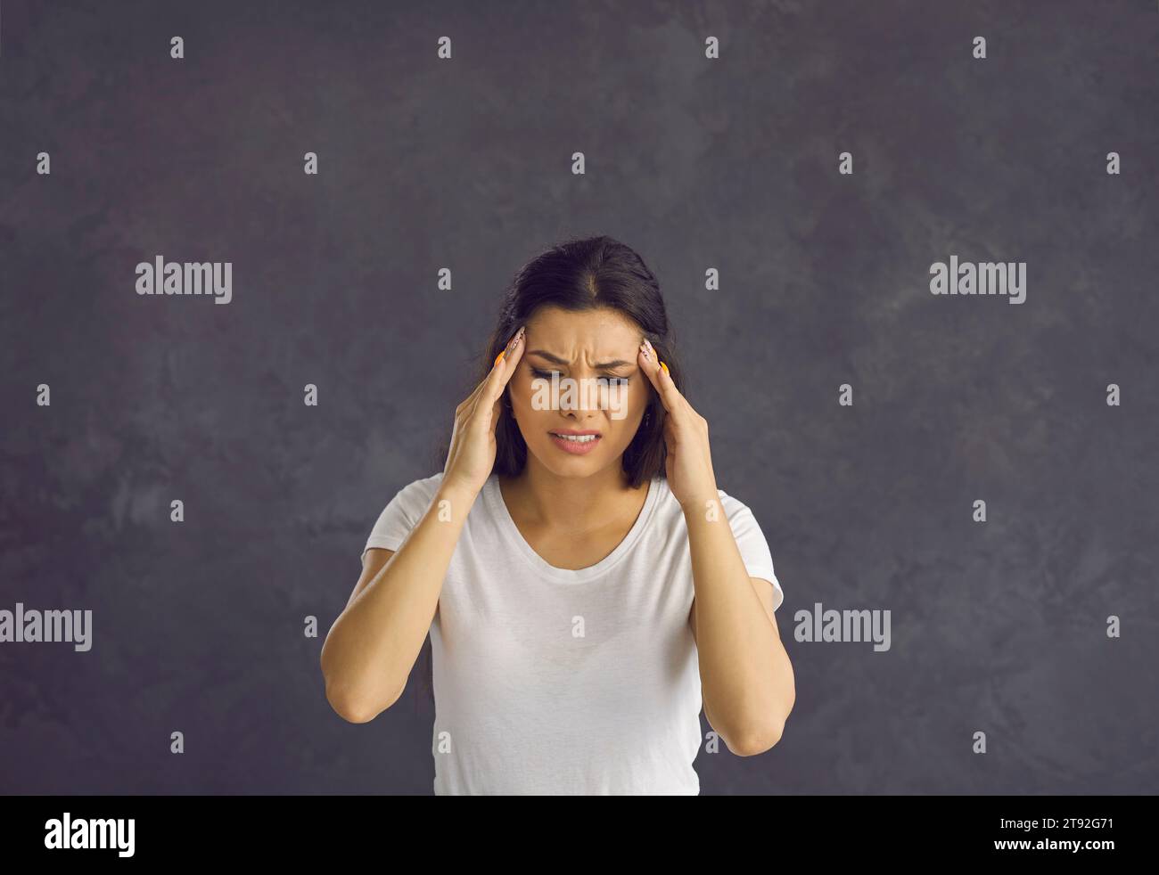 Portrait of anxious young woman touching her temples feeling severe ...