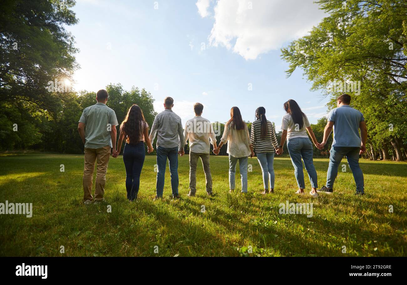 Group of best friends holding hands stand in row under sunlight in ...
