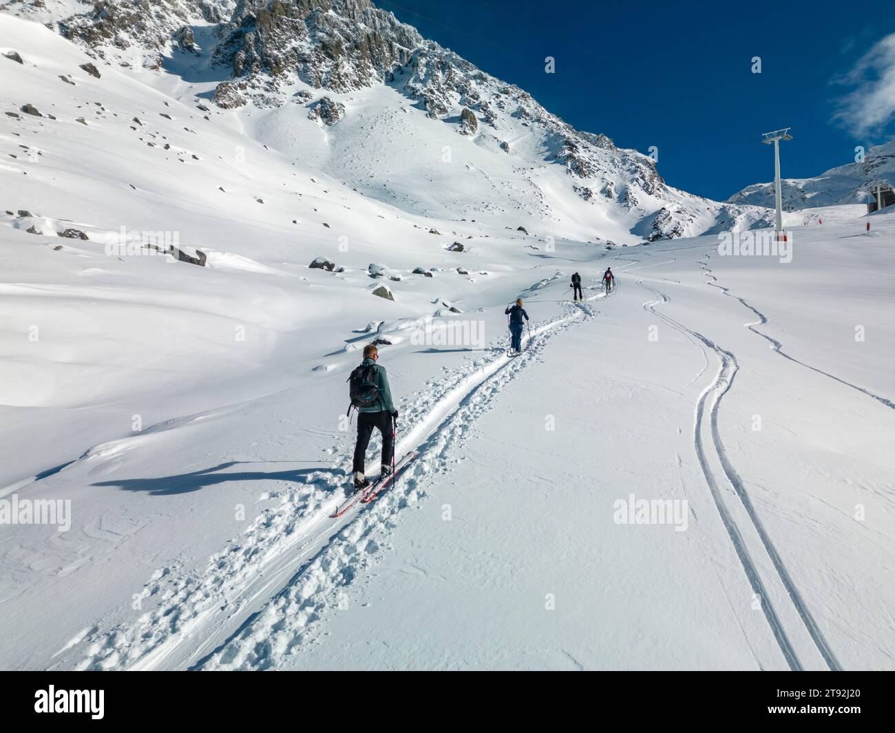 Tourists ski amid the snow-covered landscape of Val Thorens, with a ...
