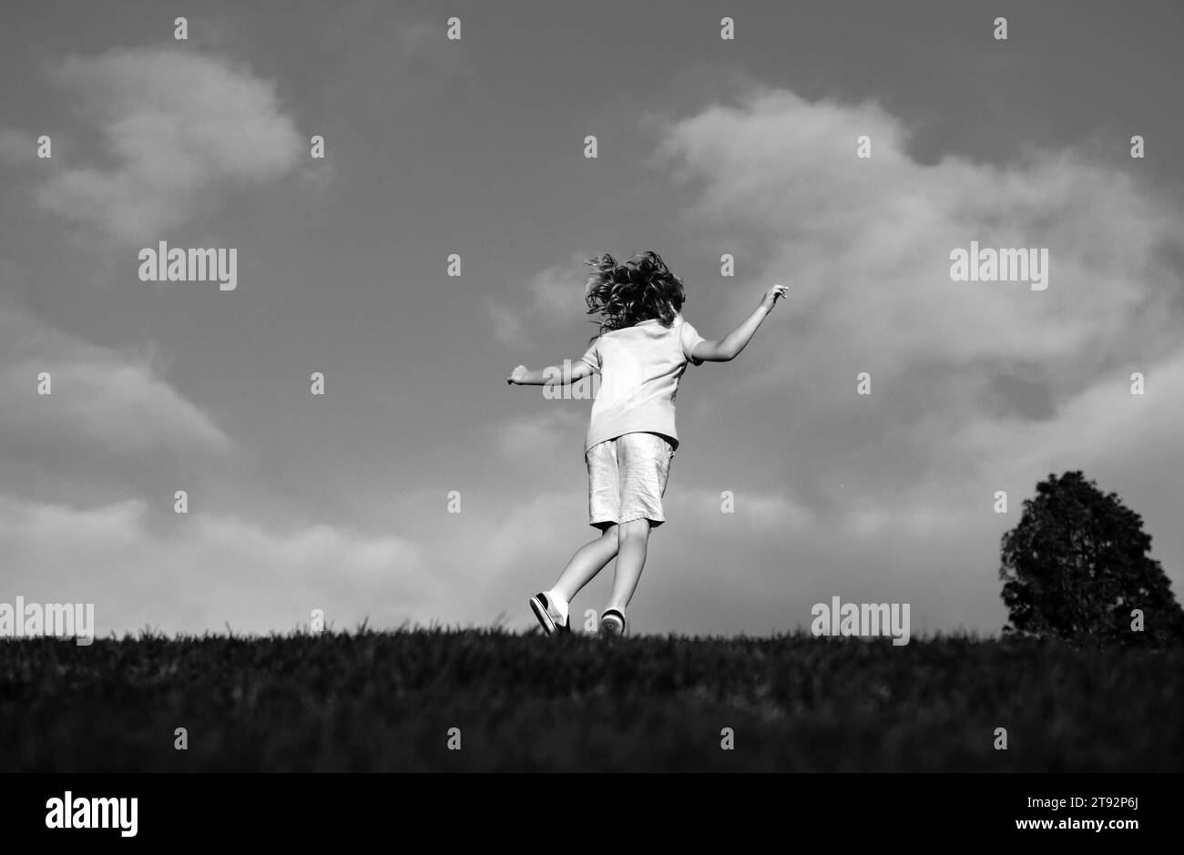 Child boy running on meadow. Back view of kid run on beautiful summer ...