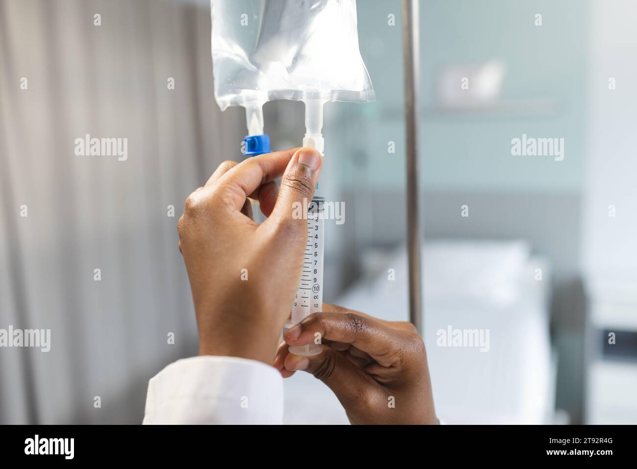 Hands of african american female doctor applying drip in hospital room ...