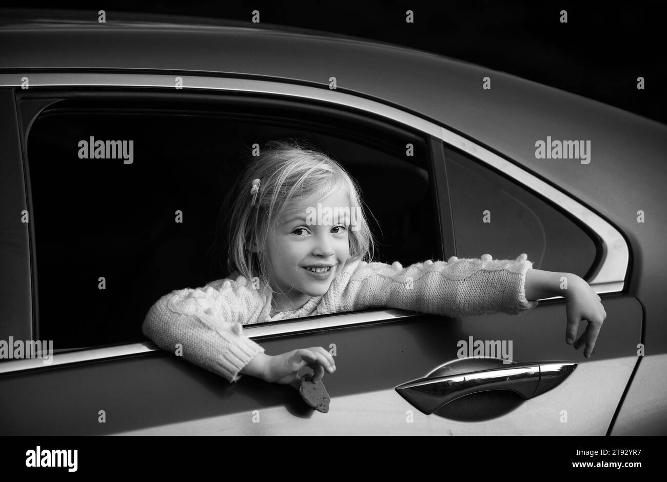 Sweet female child looking trough car window. Cute pensive girl looking ...