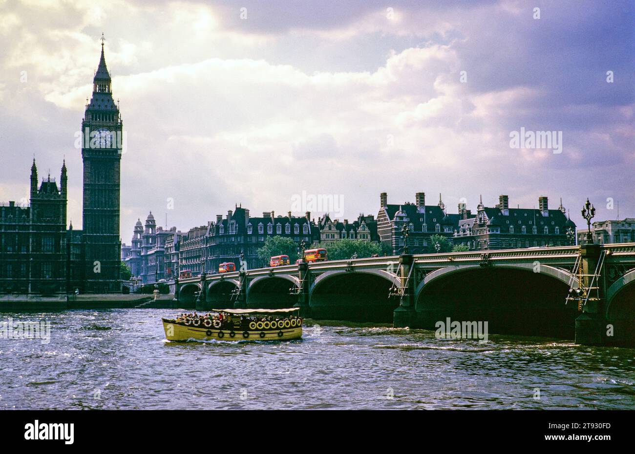 Big Ben and Westminster Bridge with red double-decker buses and boat on River Thames, London ...