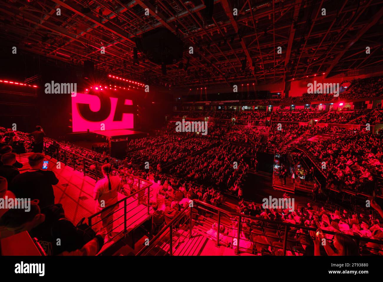 Aerial view of business crowd enjoying concert in large illuminated red ...