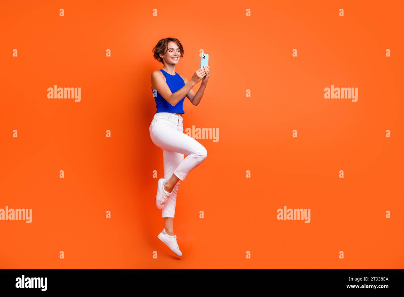 Full body profile photo of lovely active lady jump use smart phone ...