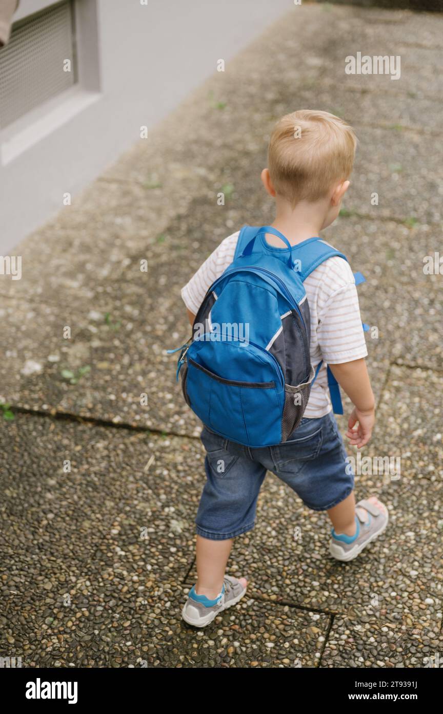 From above back view of anonymous carefree preschool kid looking down ...