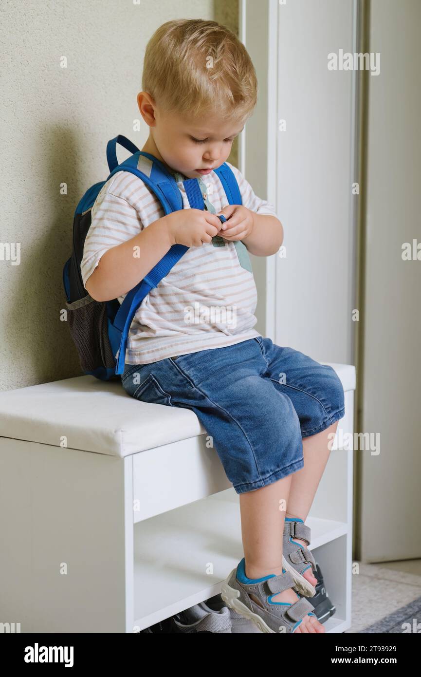 Side view of focused preschool cute boy in casual clothes looking down ...