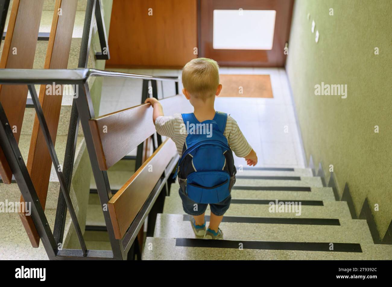 Back view of anonymous preschool boy in casual clothes with backpack ...