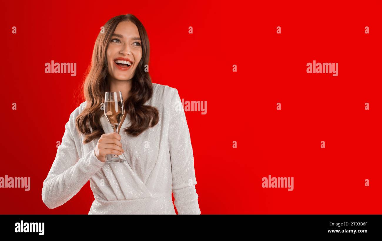 lady cheerfully toasting with wine glass on red studio background Stock ...