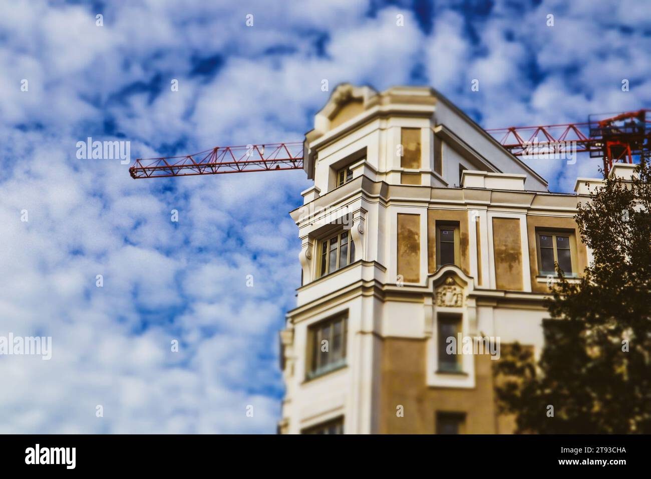 An old beige house, apartment building under construction on a city ...