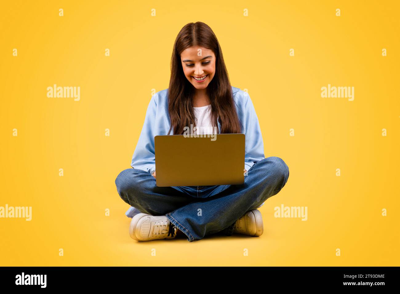 Glad caucasian teenager student lady use computer, typing and sit on ...
