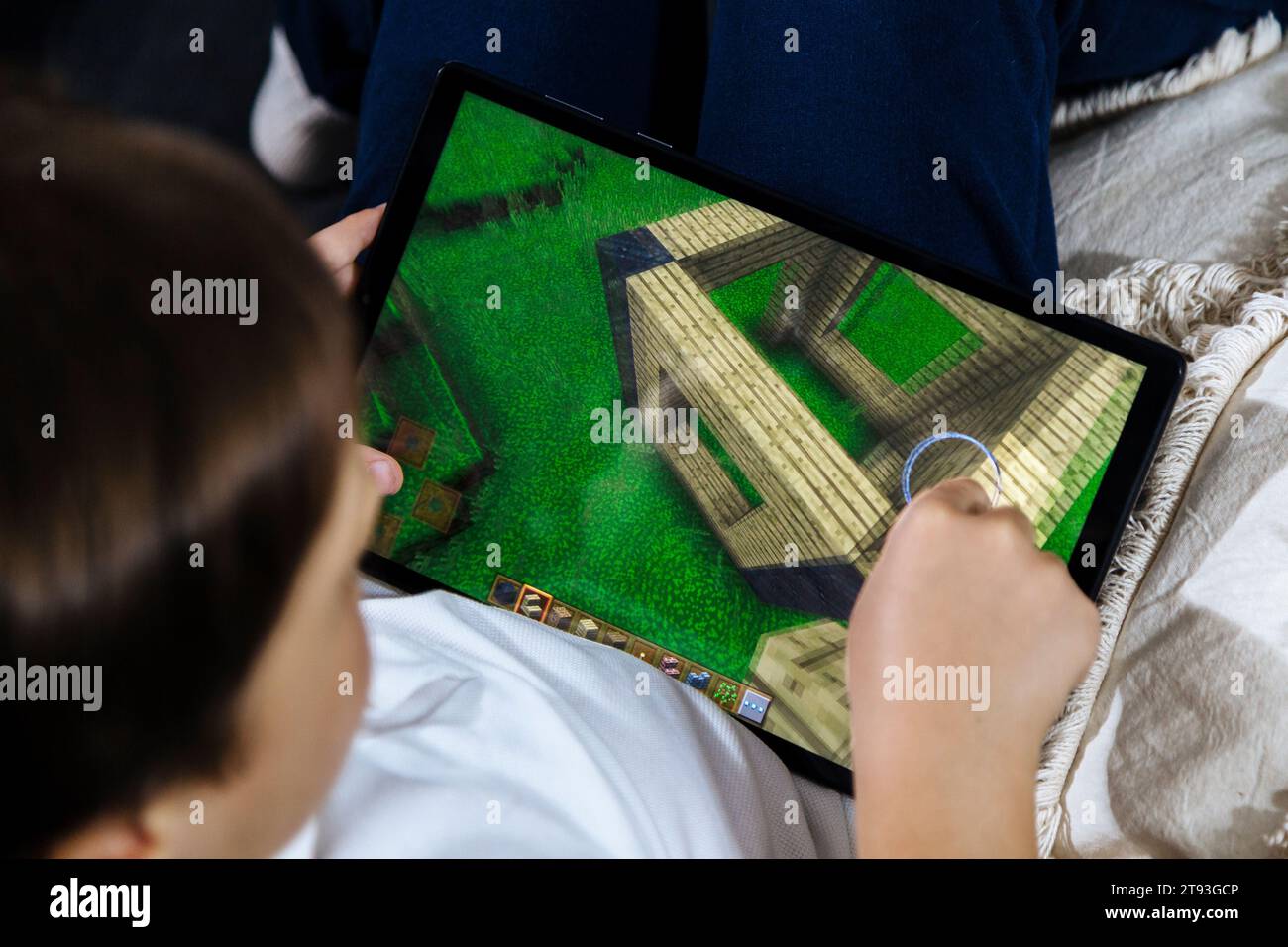 Little boy playing Minecraft game on a tablet. Minecraft is a very ...