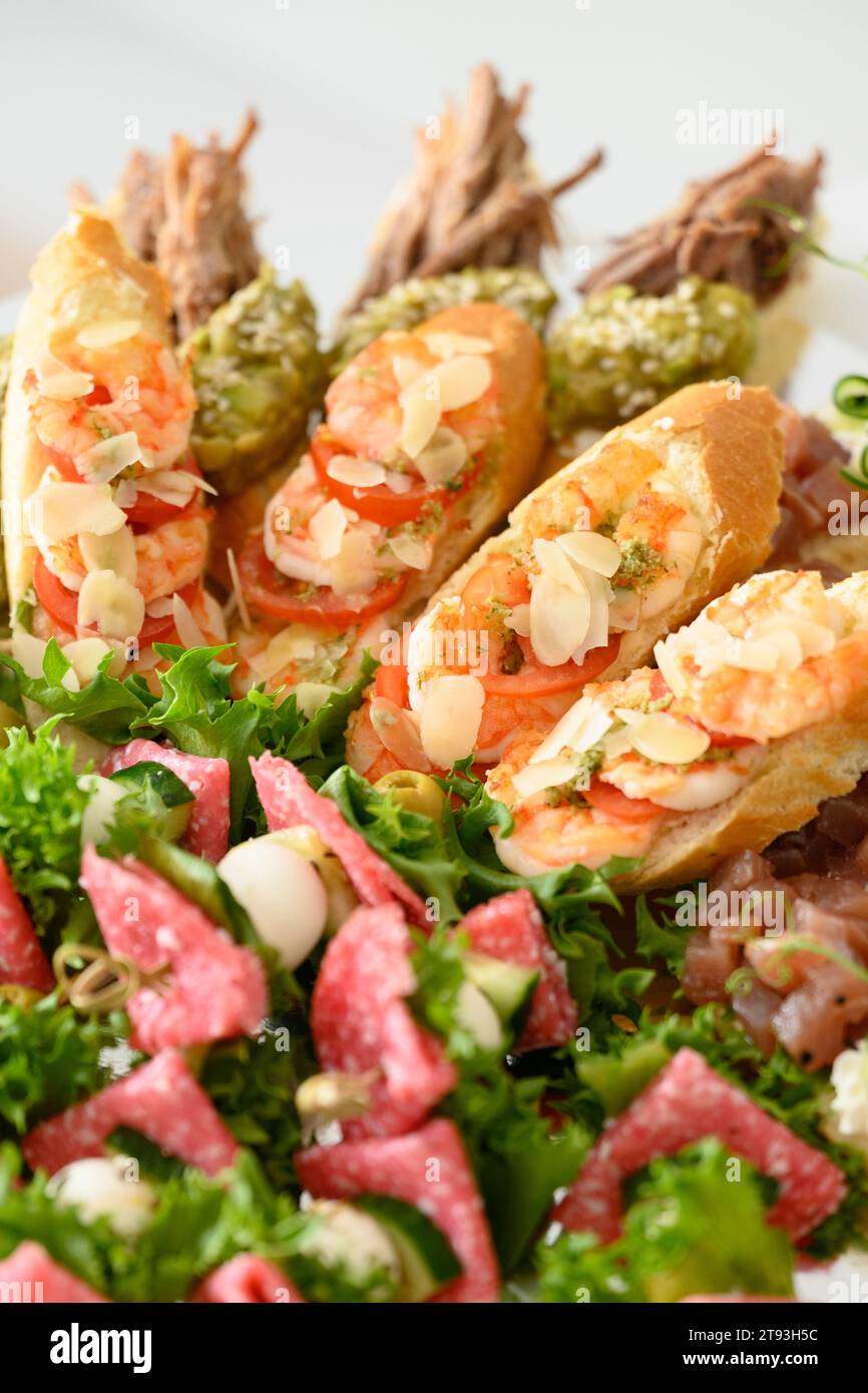 Appetizer with lettuce leaves and canapes with tomato and sausage, an ...