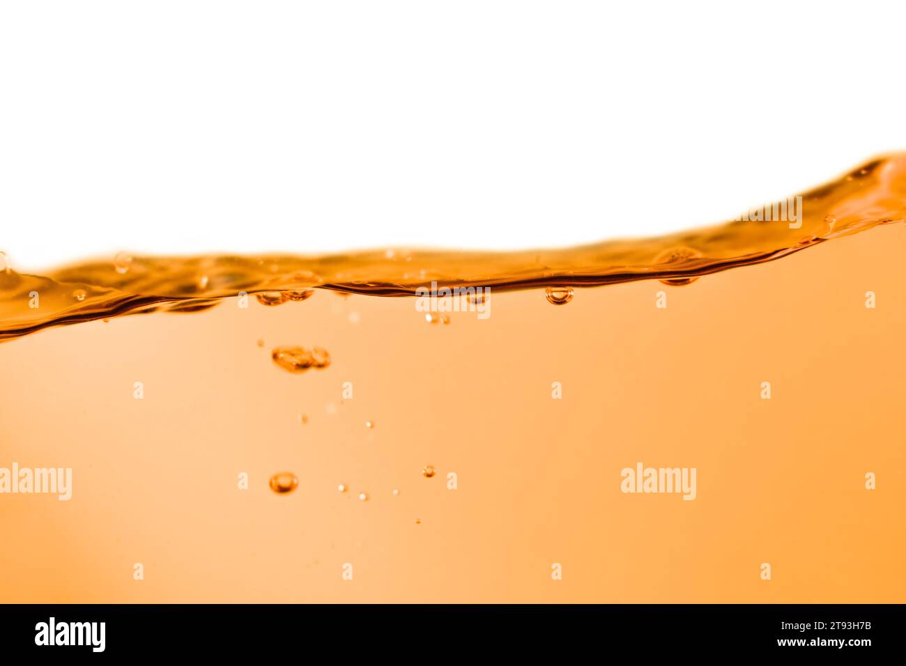 Orange water surface with splashes and bubbles on white background ...