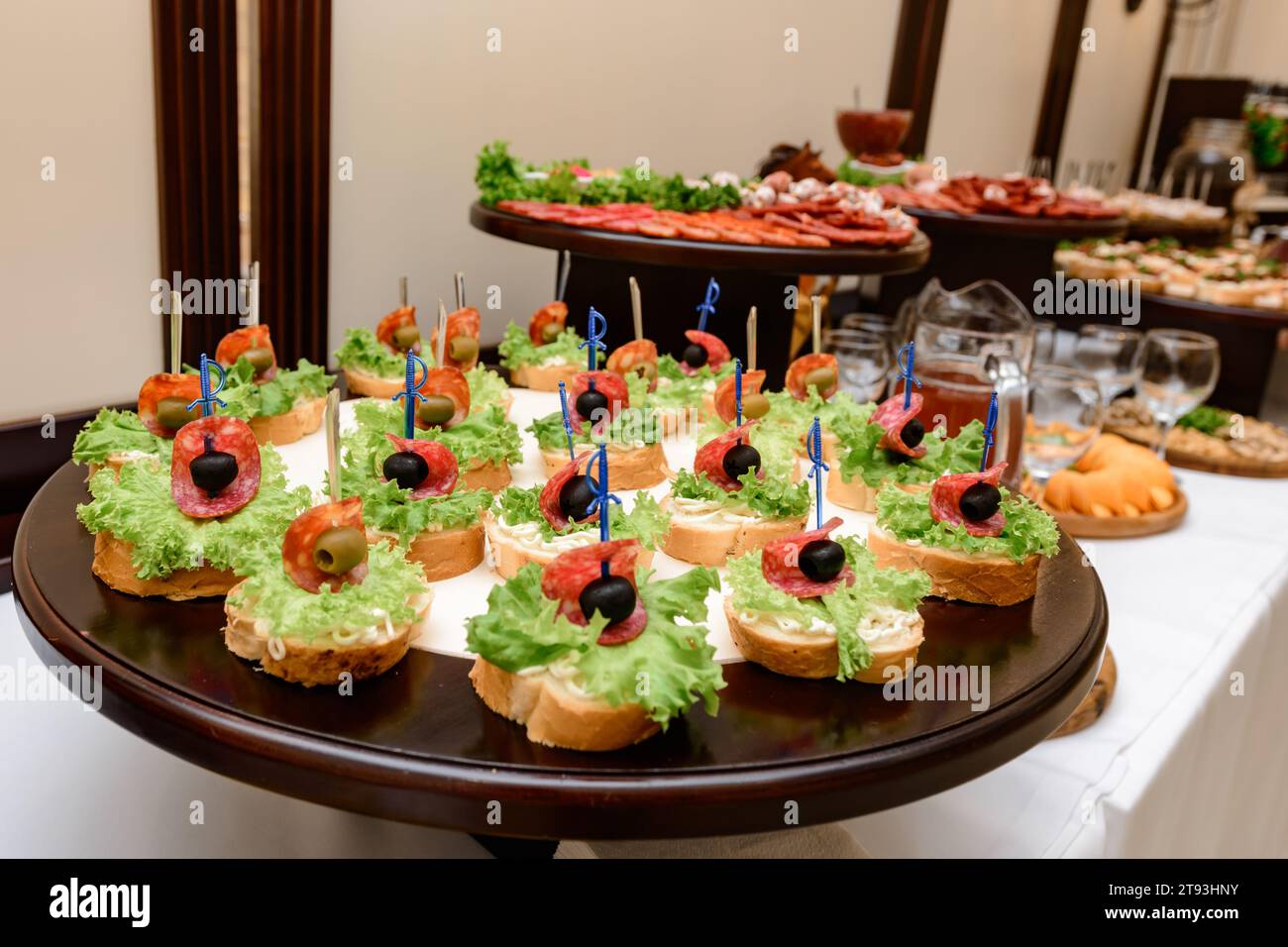 Canapes with olives, tomatoes and lettuce served as an appetizer on the ...