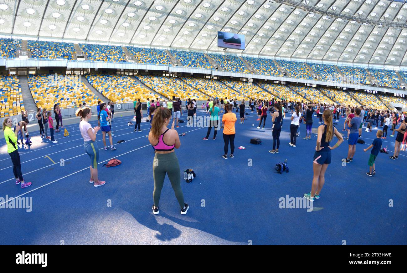 Large group of people doing morning exercises on the stadium. September ...