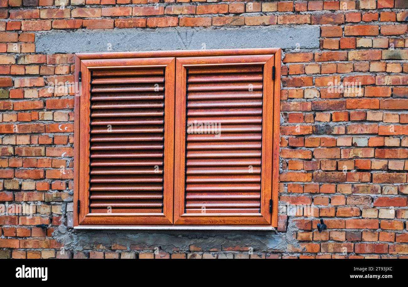 Window and shutters on a red brick house wall. Wooden window with ...