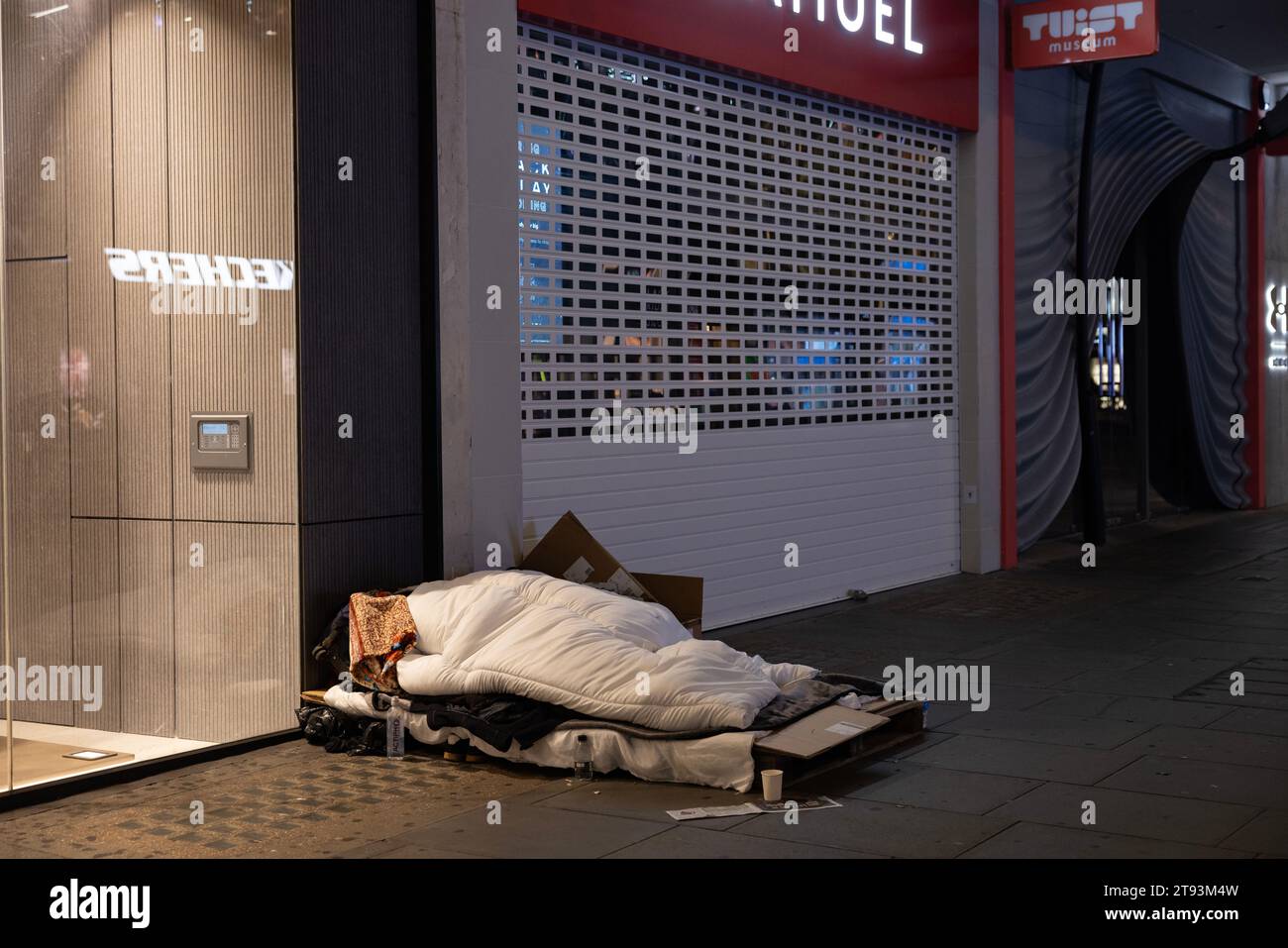 Homeless people sleeping on the pavement outside retails chain stores ...